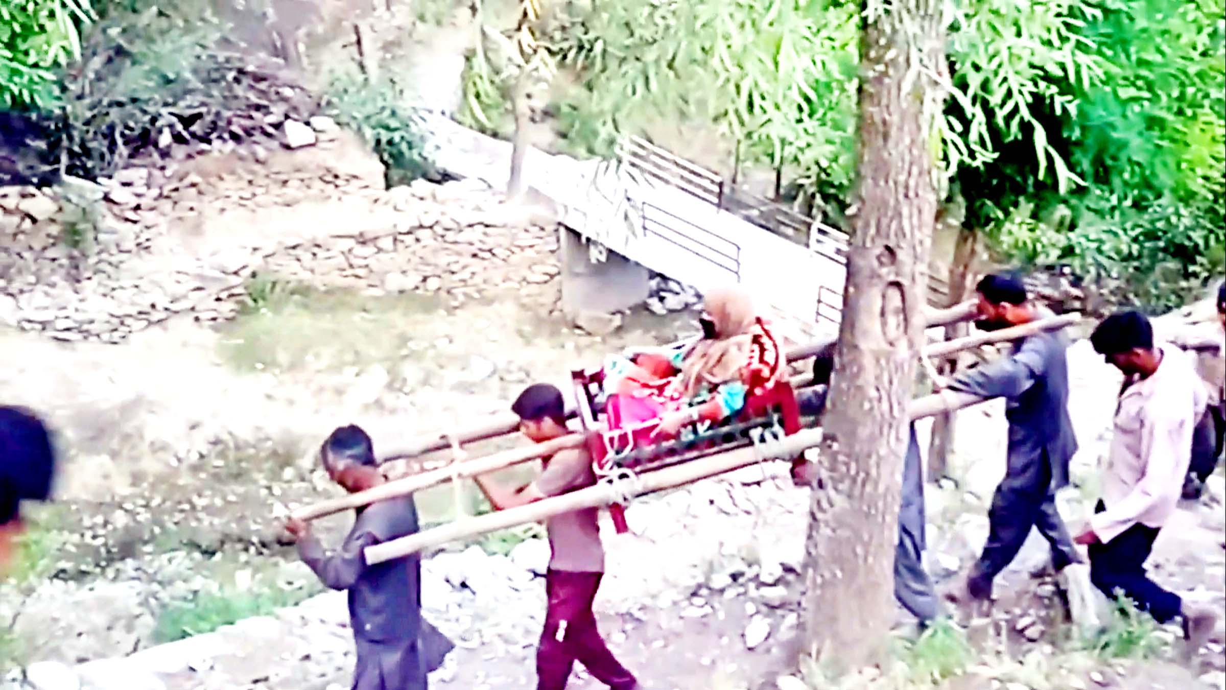 People shifting a woman to her home on makeshift wooden stretcher ...